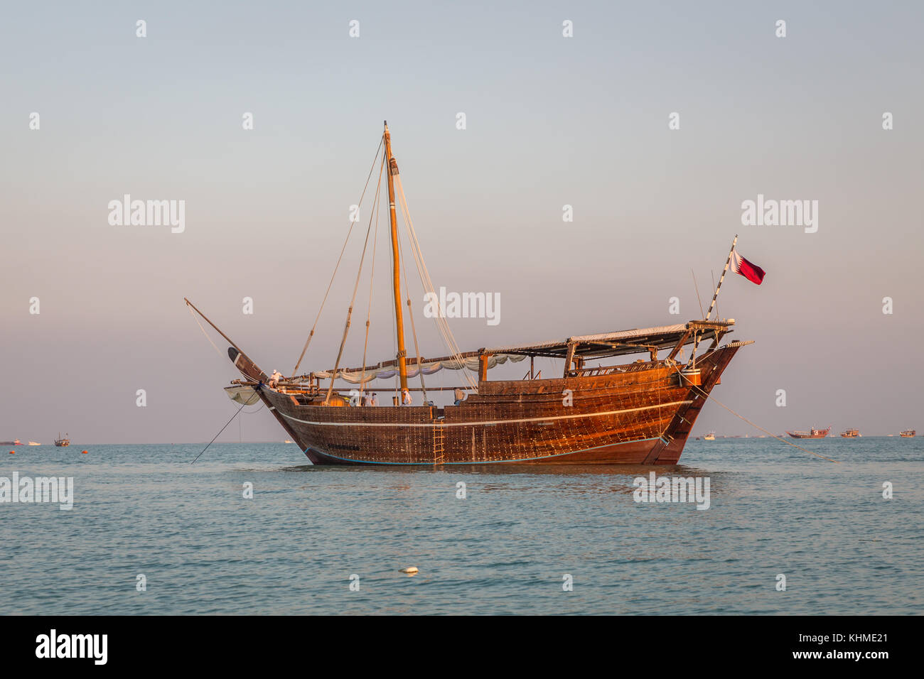 Traditional wooden boat (dhow) with Qatari flag in Katara beach, Doha ...