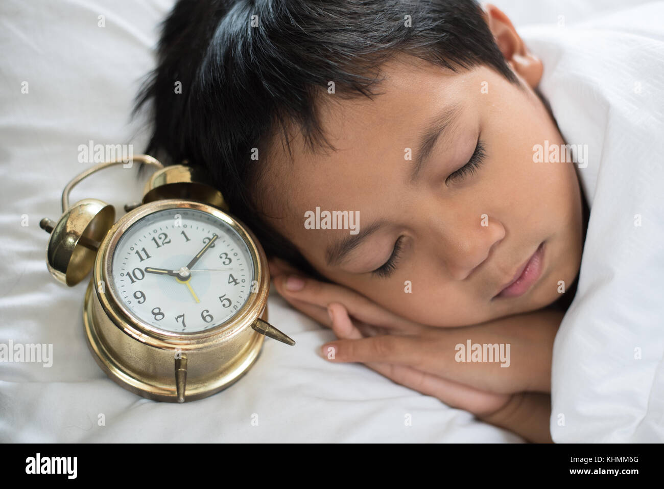 young boy sleeping with alarm clock on the bed at the morning.asian boy ...