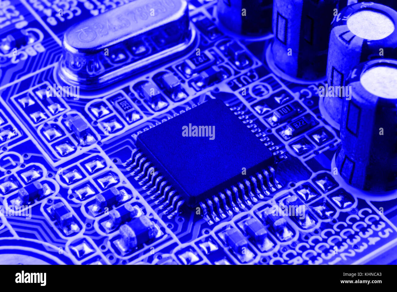 Integrated semiconductor microchip on blue circuit board representative ...
