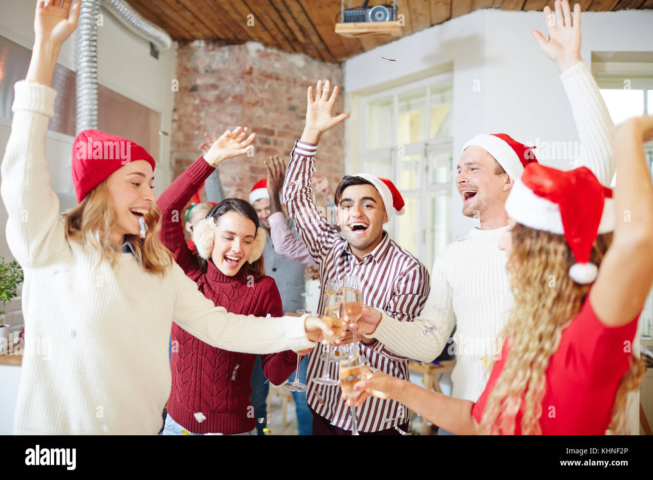 Joyful dancing friends cheering up with champagne and having fun at ...