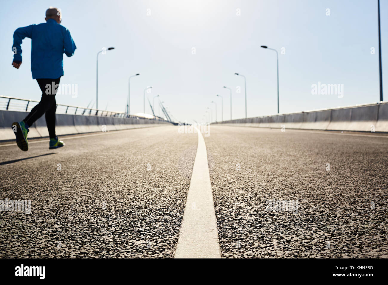Central line of cycling road in perspective and sportsman jogging along ...