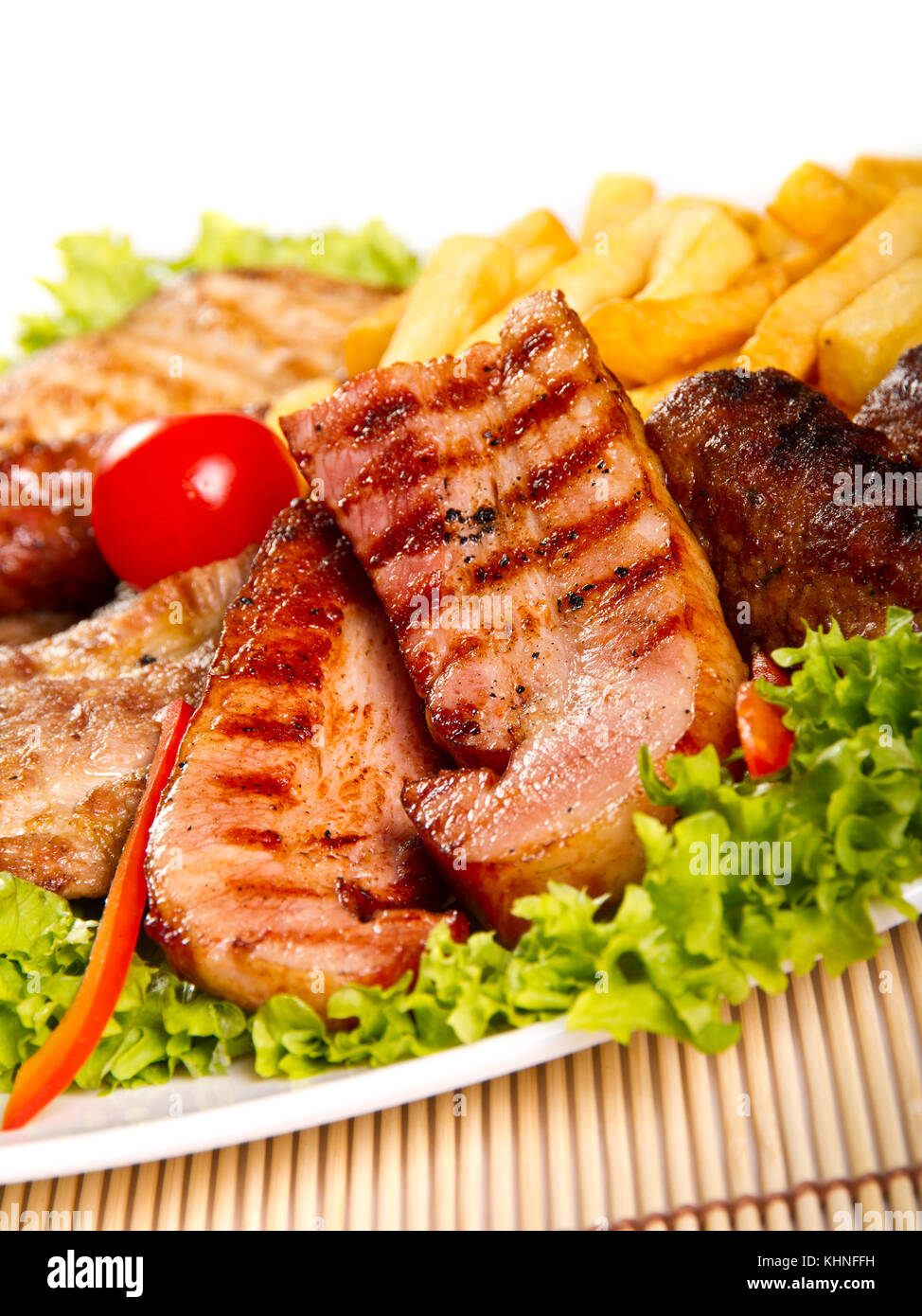 Variety of grilled meat with fries Stock Photo - Alamy