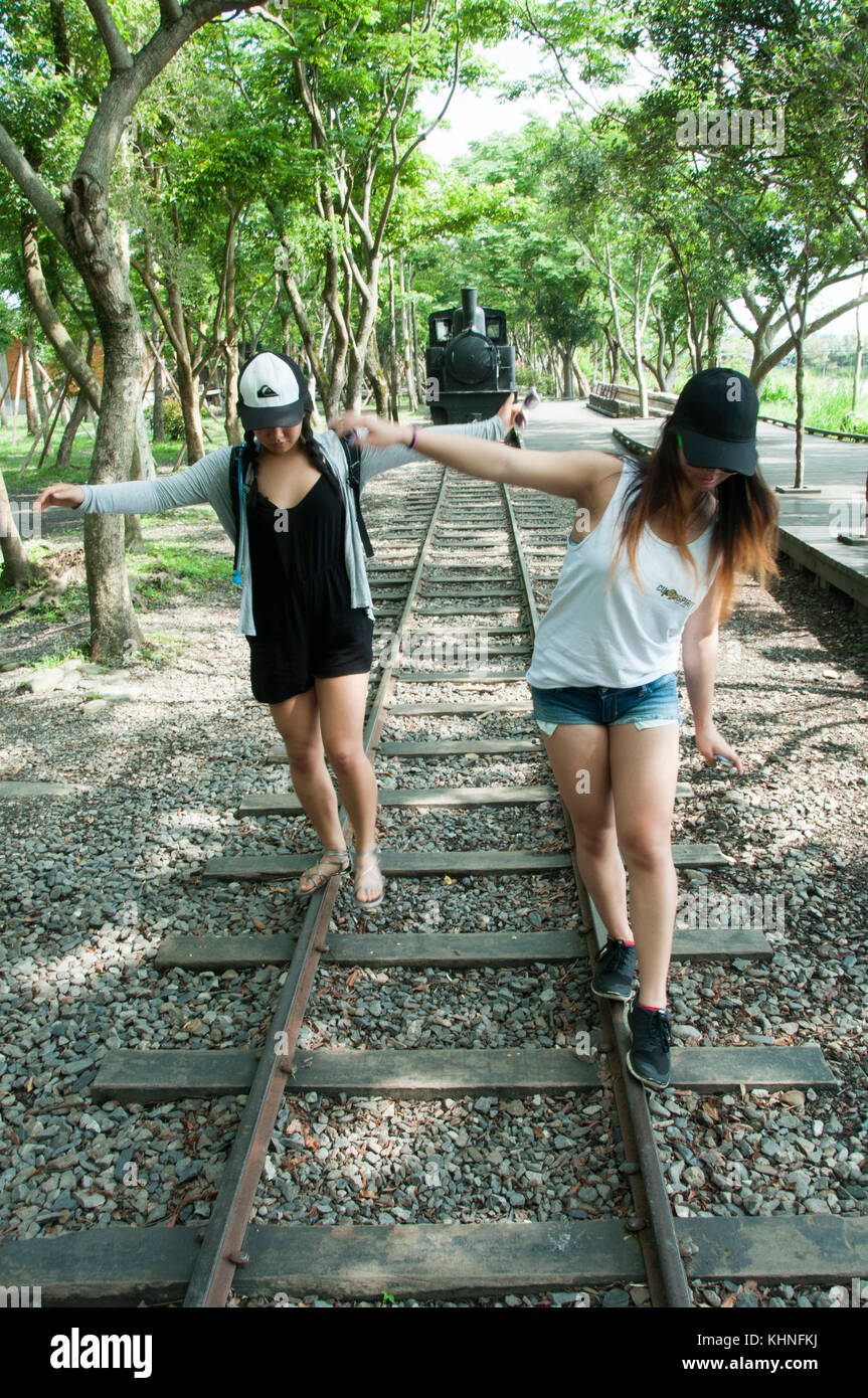 Two girls walking down the railroad track keeping their balance Stock ...