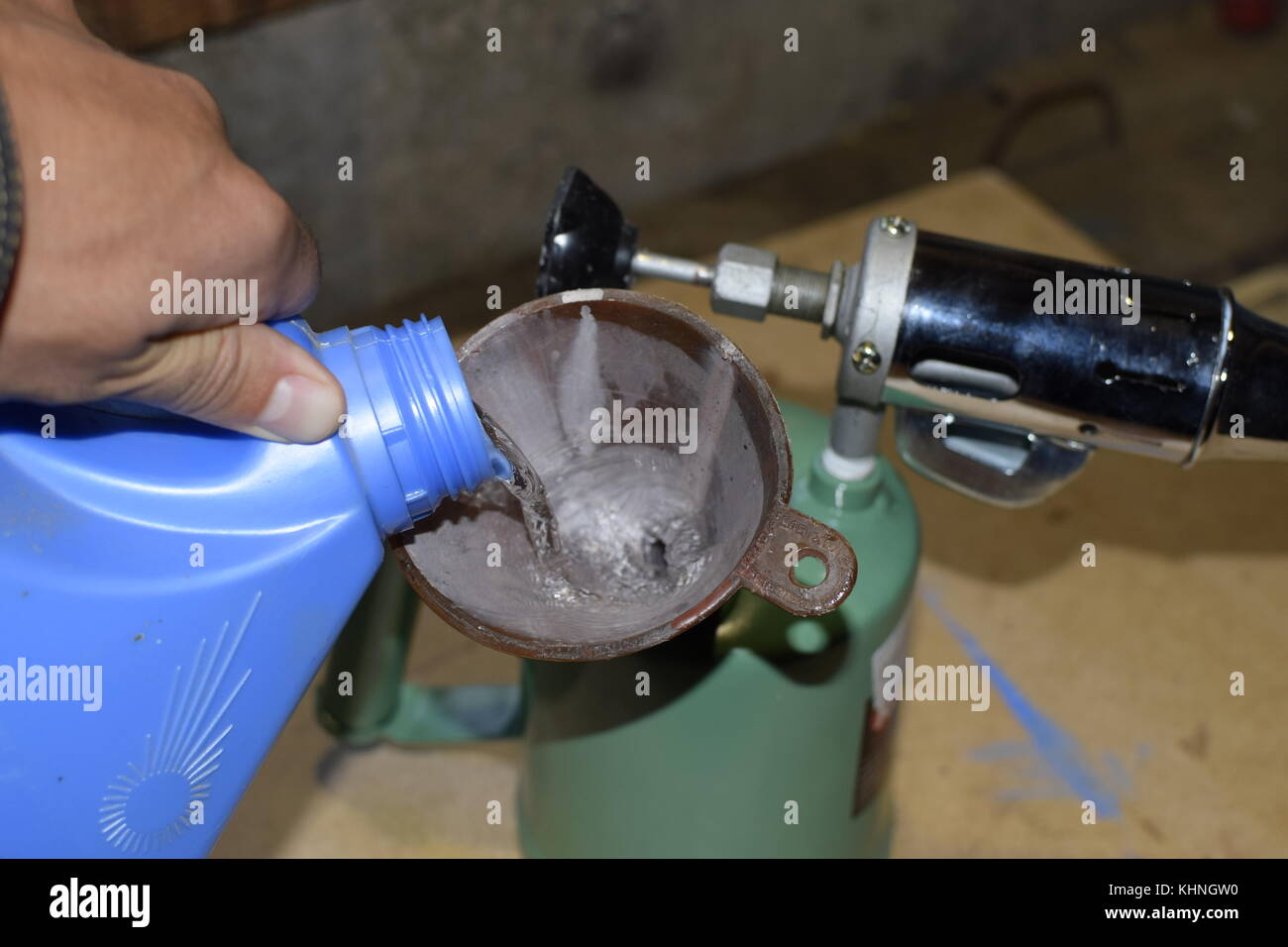 Pouring gasoline blowtorch through the funnel Stock Photo - Alamy