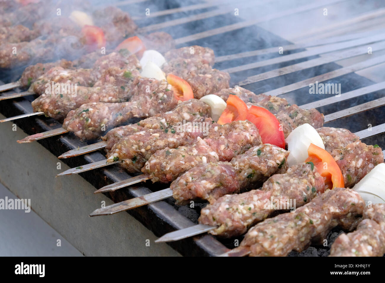 Kebabs also kabobs meat on skewers being barbecued at a food stall in ...