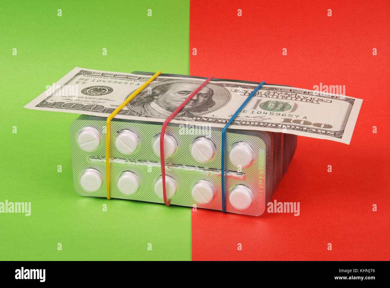Hundred dollars lays on packing of white tablets. Red and green ...