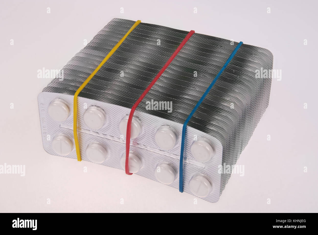 Plenty of white tablets in packing. Silver packs pills. On grey ...