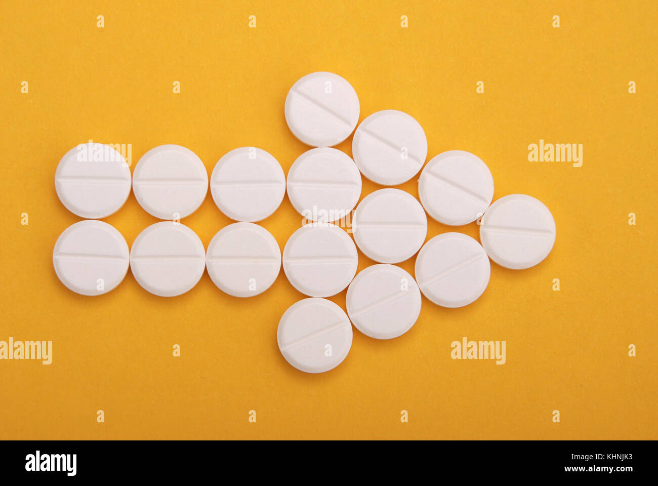 Arrow of Pills on yellow background Stock Photo - Alamy