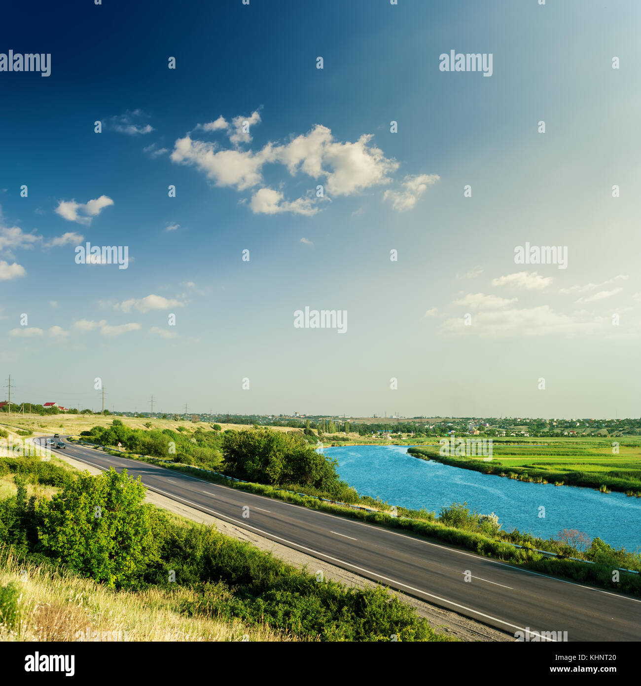 asphalt road and river under sunset in blue sky with clouds Stock Photo ...