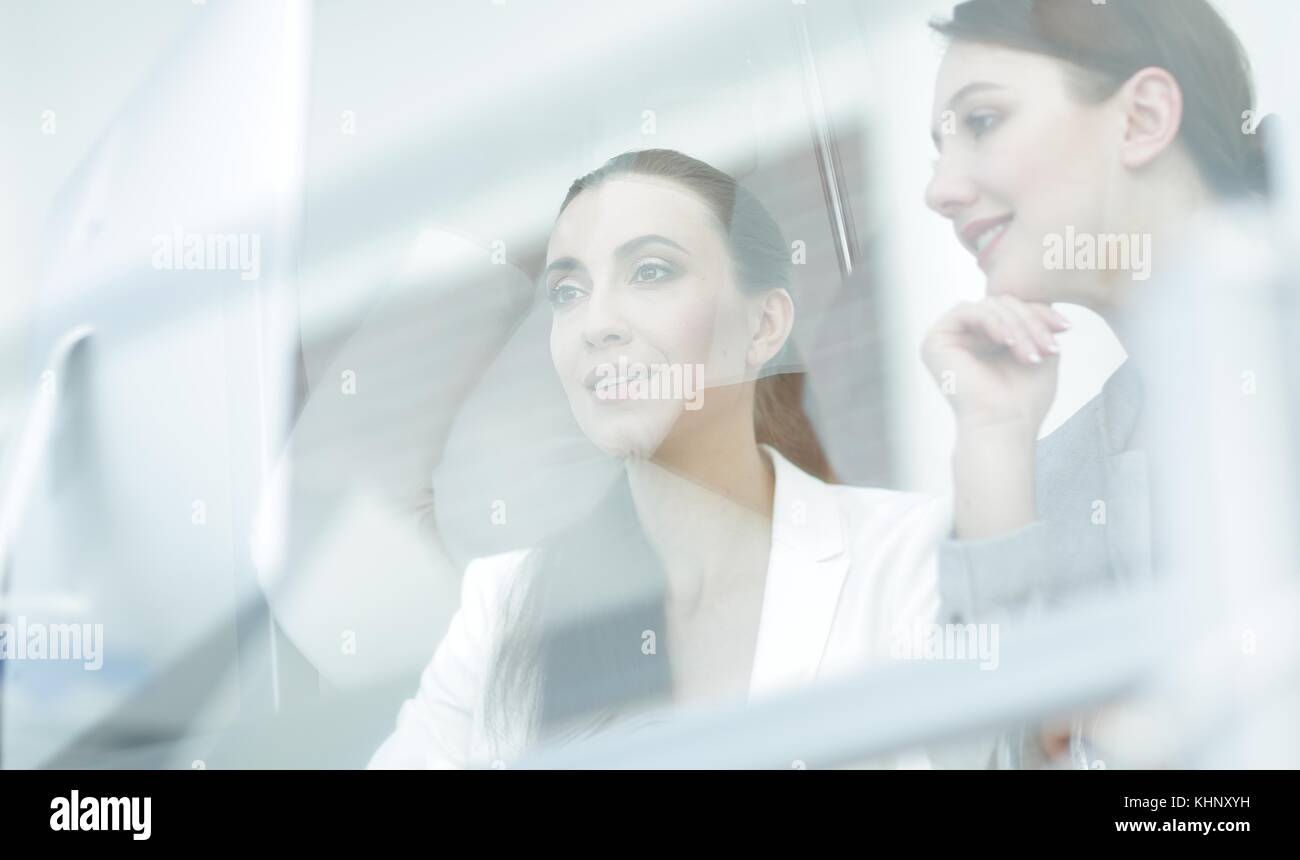 behind the glass.business team sitting at Desk Stock Photo - Alamy