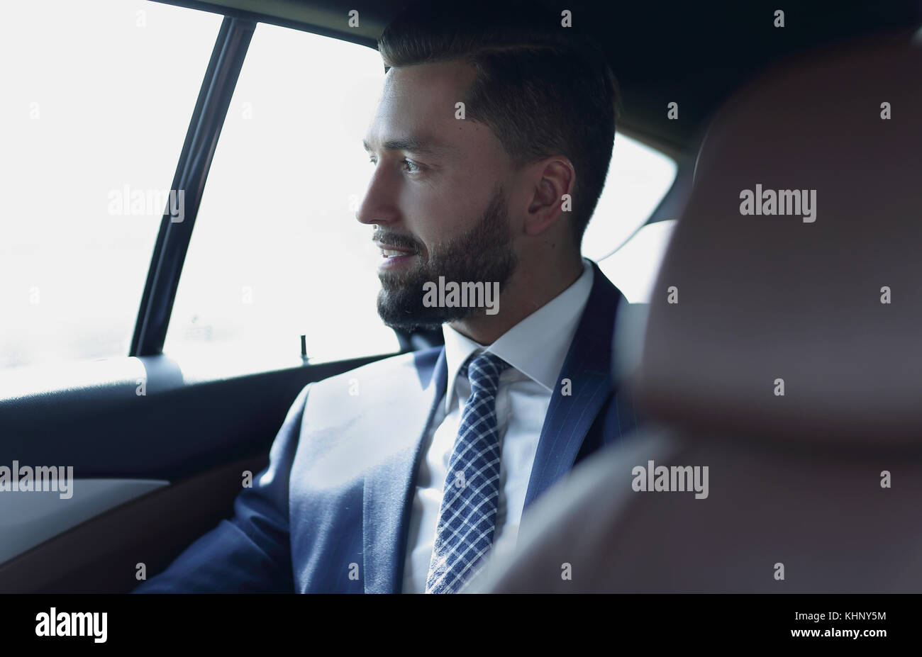 Smiling business man sitting in the back seat of a car Stock Photo - Alamy