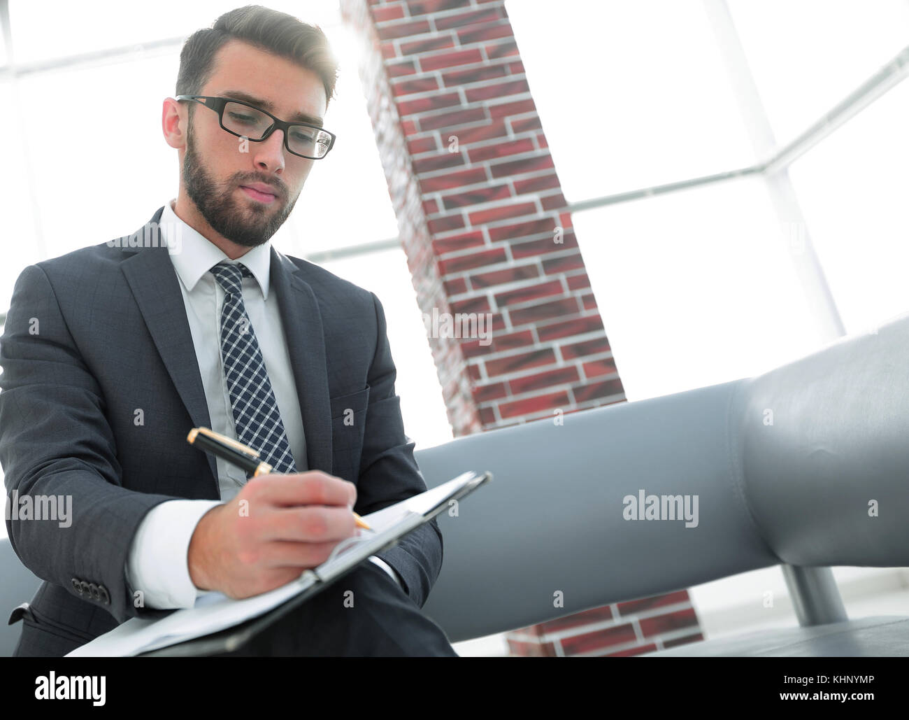 Businessman writing in a notebook in an office Stock Photo - Alamy