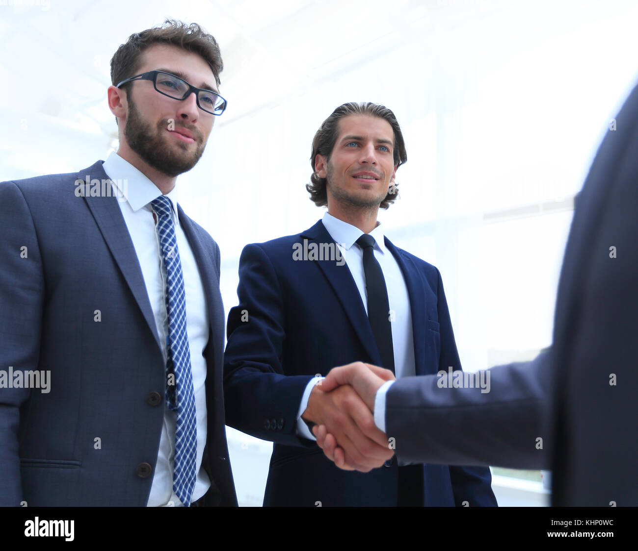business group welcomes partner with a handshake Stock Photo - Alamy