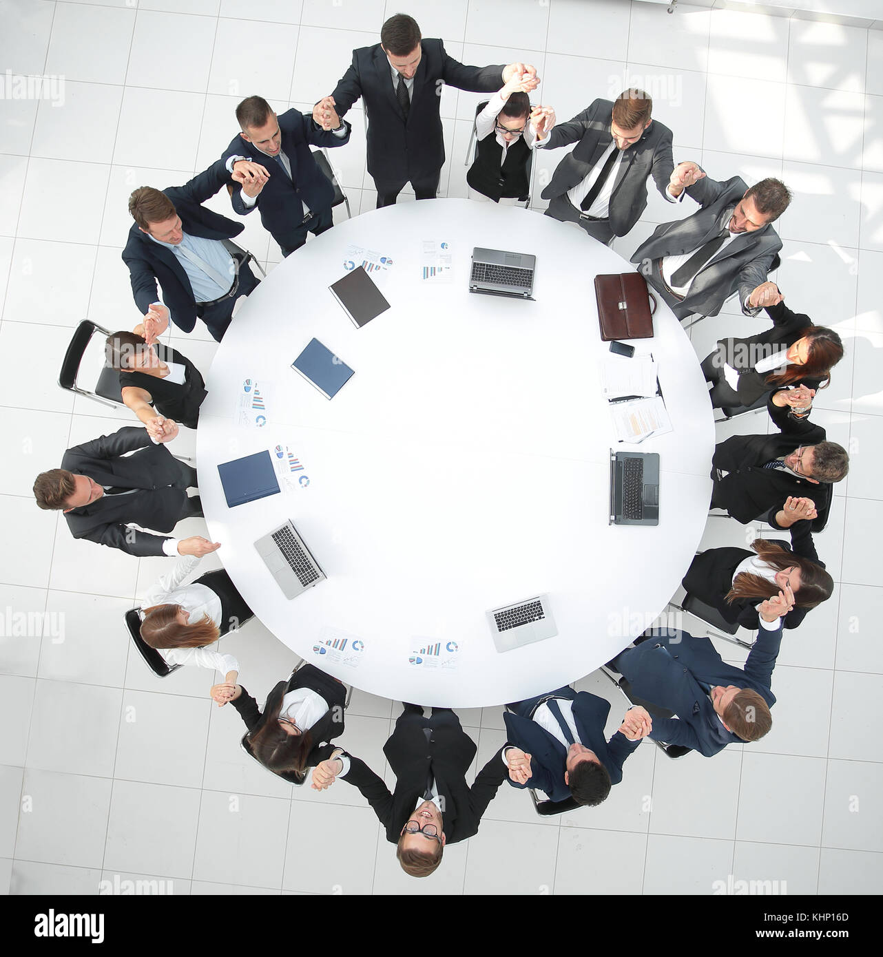 large business team sitting at the round table and raising his hands up ...