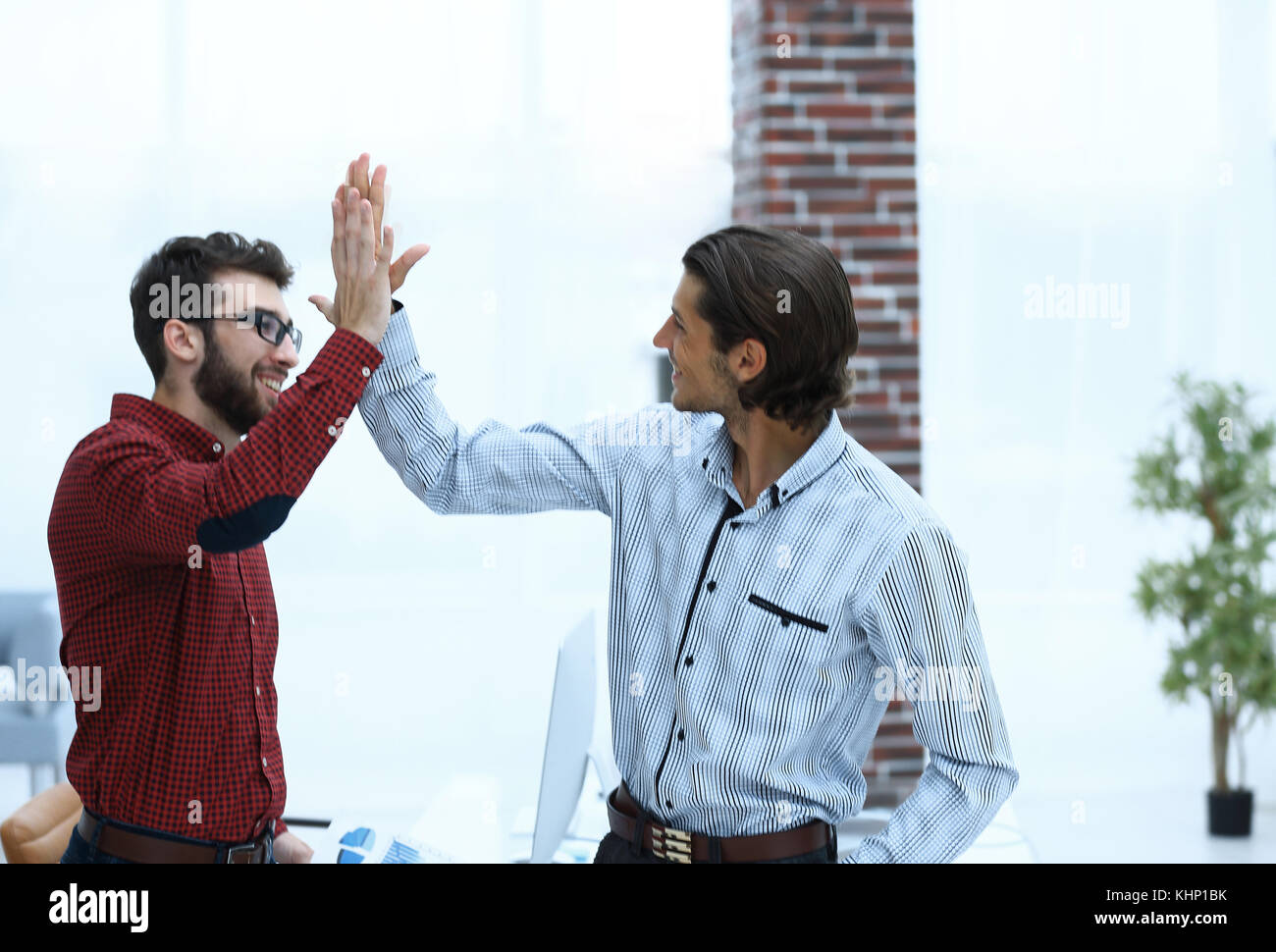 two colleagues giving each other high-five Stock Photo - Alamy