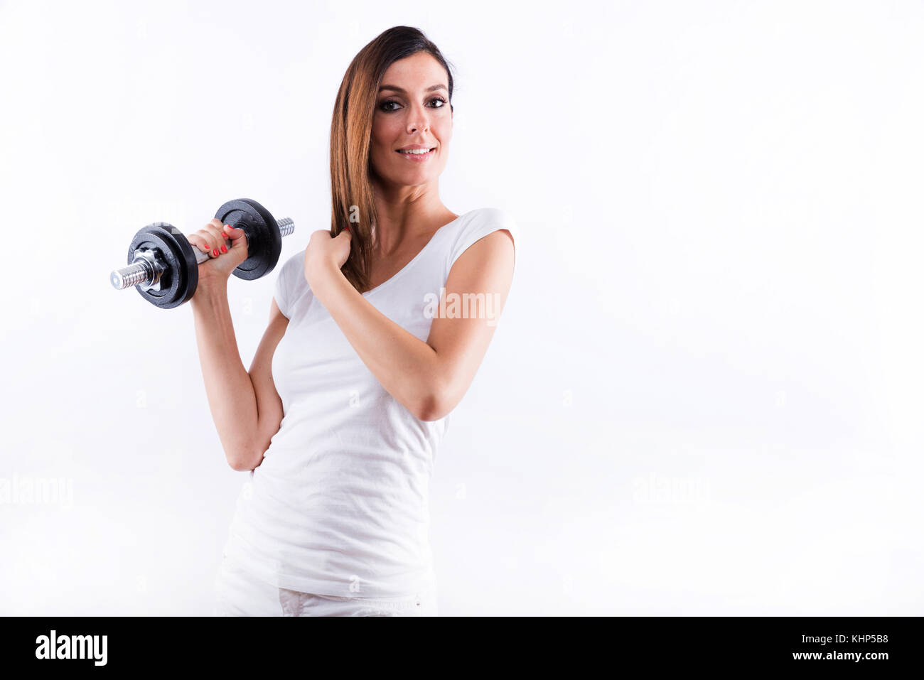 A beautiful young woman lifting weight and smiling Stock Photo - Alamy