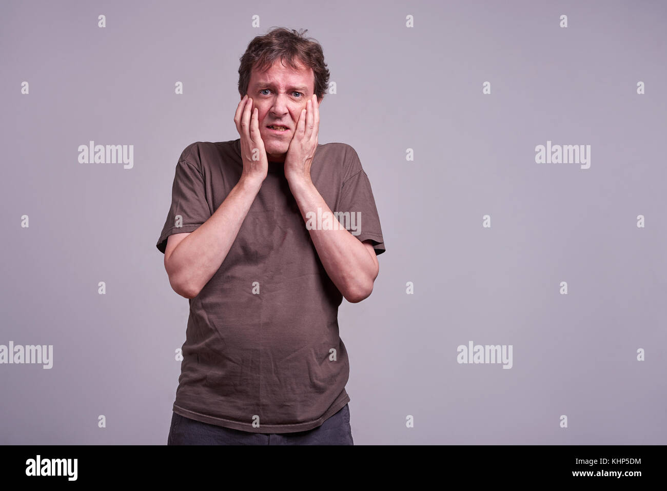 A middle aged man standing and feeling scared Stock Photo - Alamy
