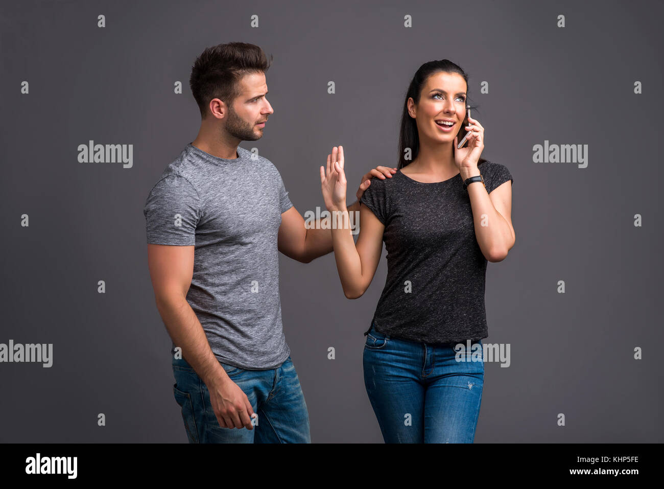 A beautiful young woman standing and talking on her phone and ignoring ...