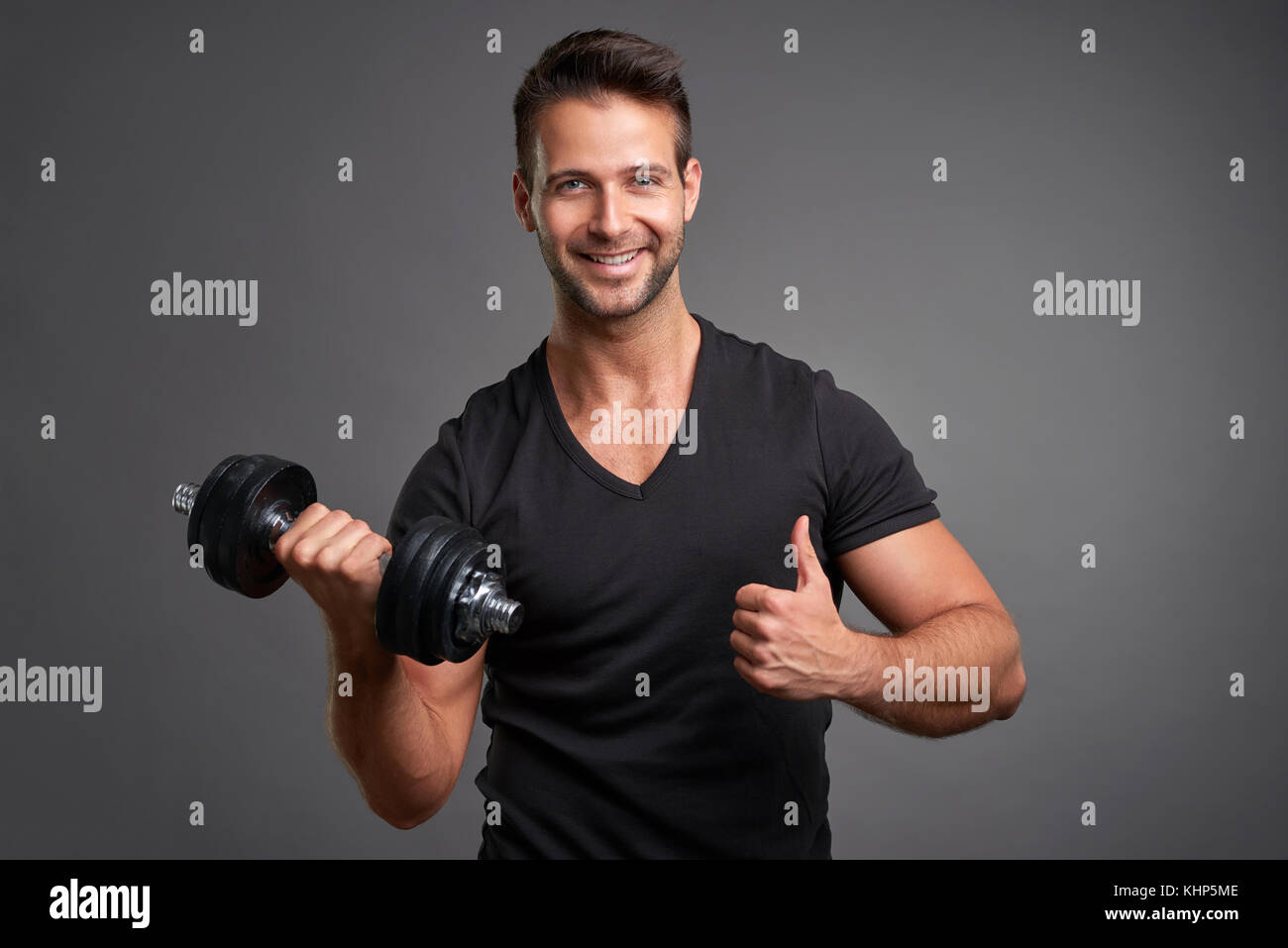 A handsome young man lifting weight smiling and showing thumbs up Stock ...