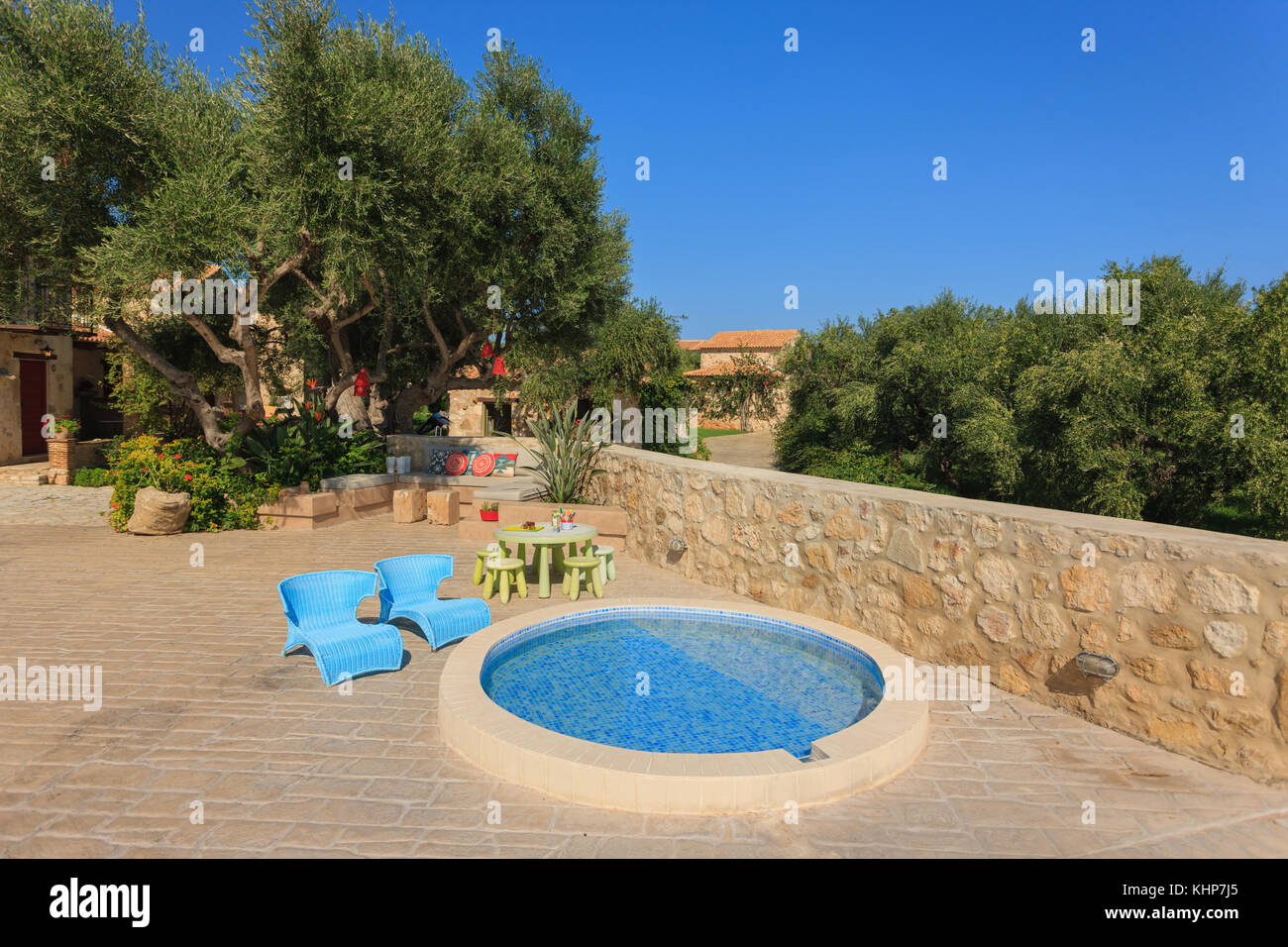 closeup of a small pool with blue stylish sunbeds in a summer resort ...