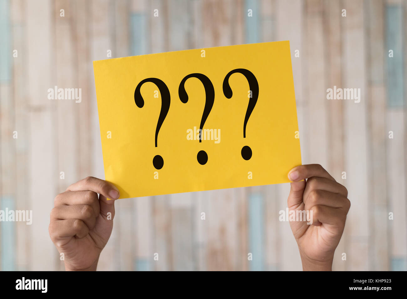 hand holding a paper note with question mark.question mark written on ...