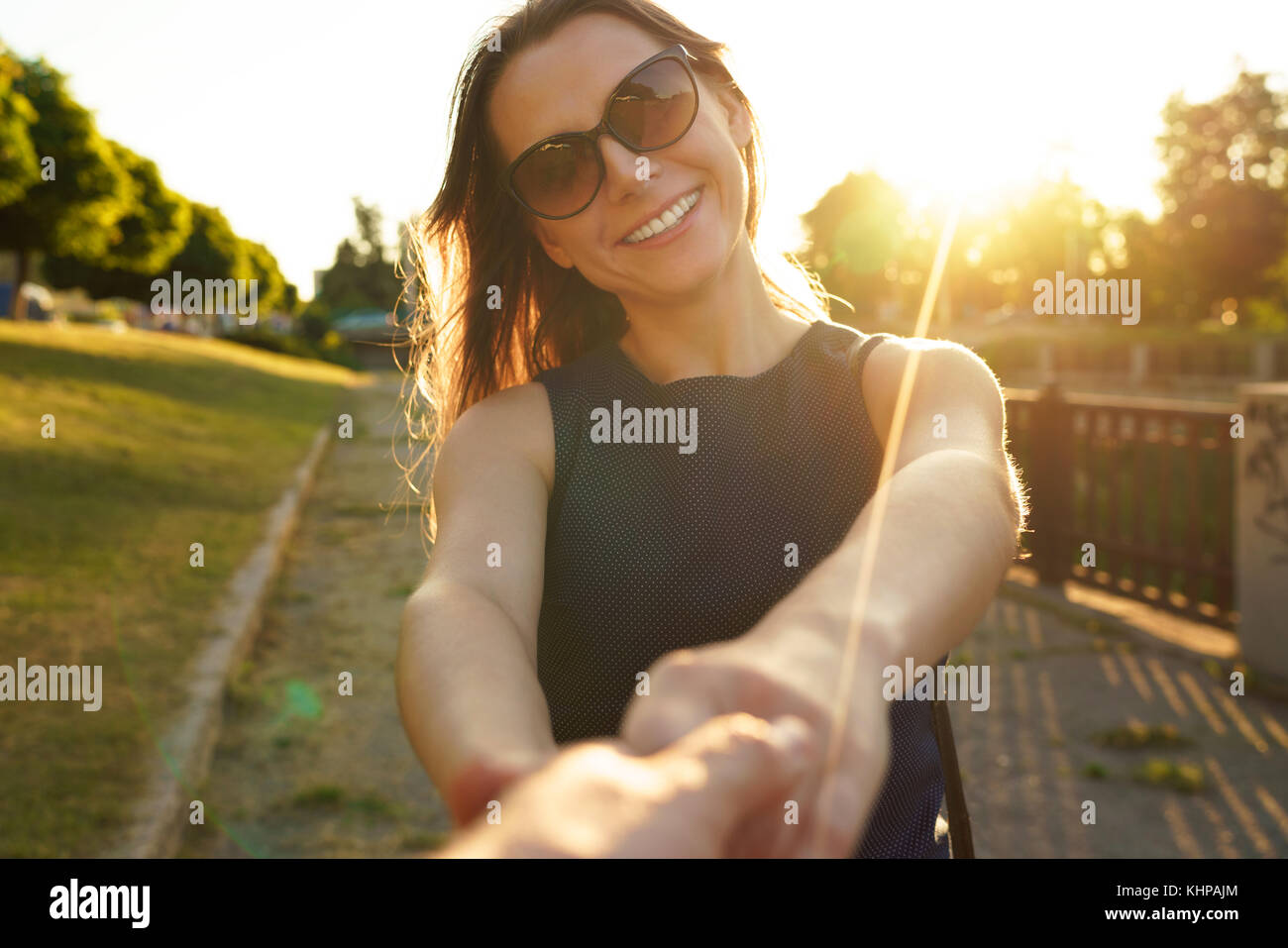 Follow me - happy young woman pulling guy's hand - hand in hand walking ...