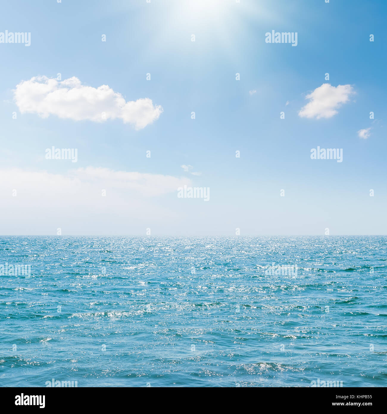 sun in blue sky over sea Stock Photo - Alamy
