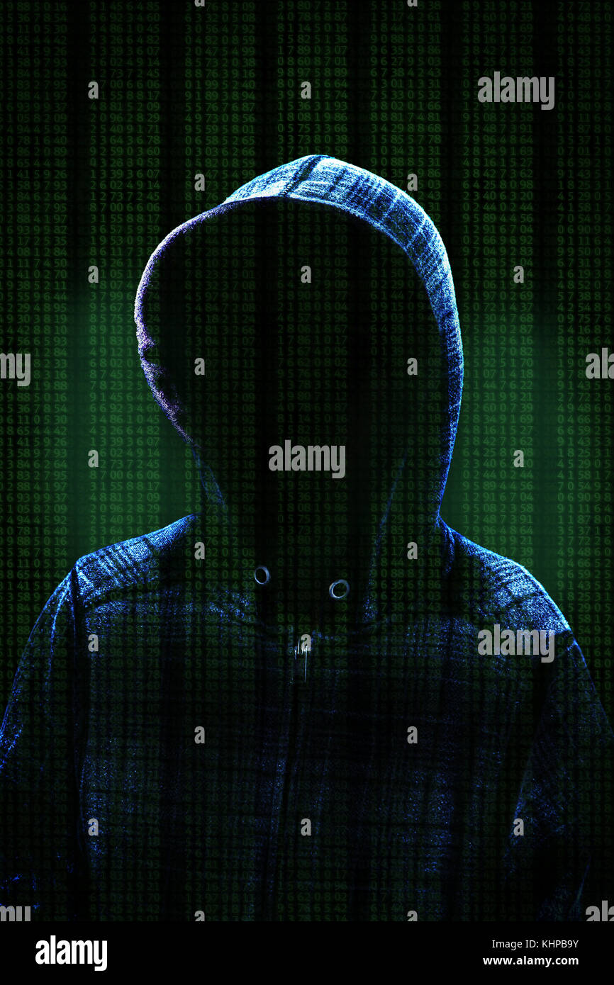 Unknown computer hacker with hood against background data and dramatic ...