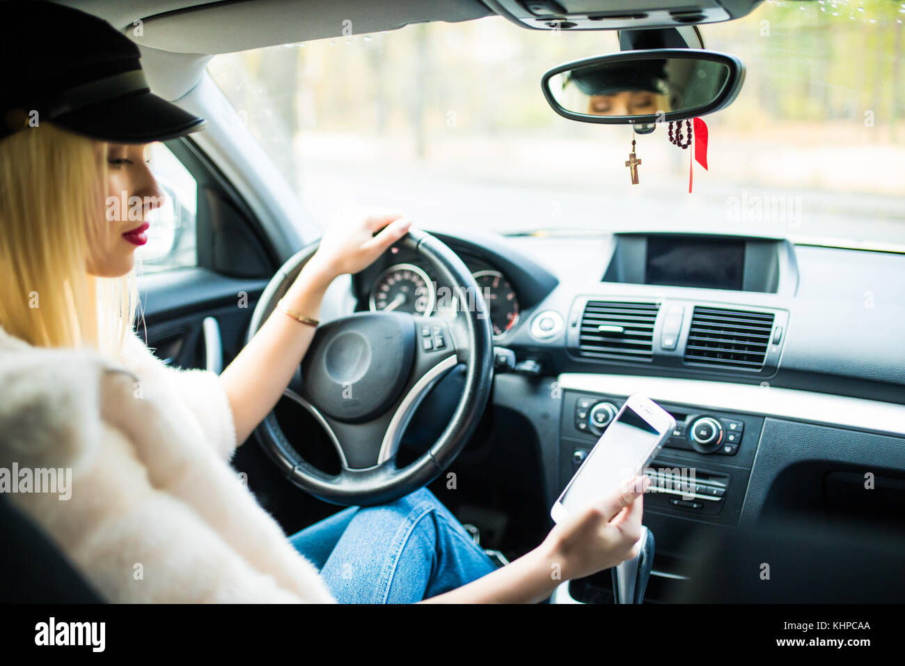 Young female driver using touch screen smartphone and gps navigation in ...