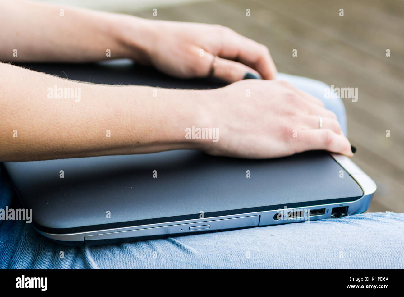 Closeup of hands resting on closed laptop Stock Photo - Alamy