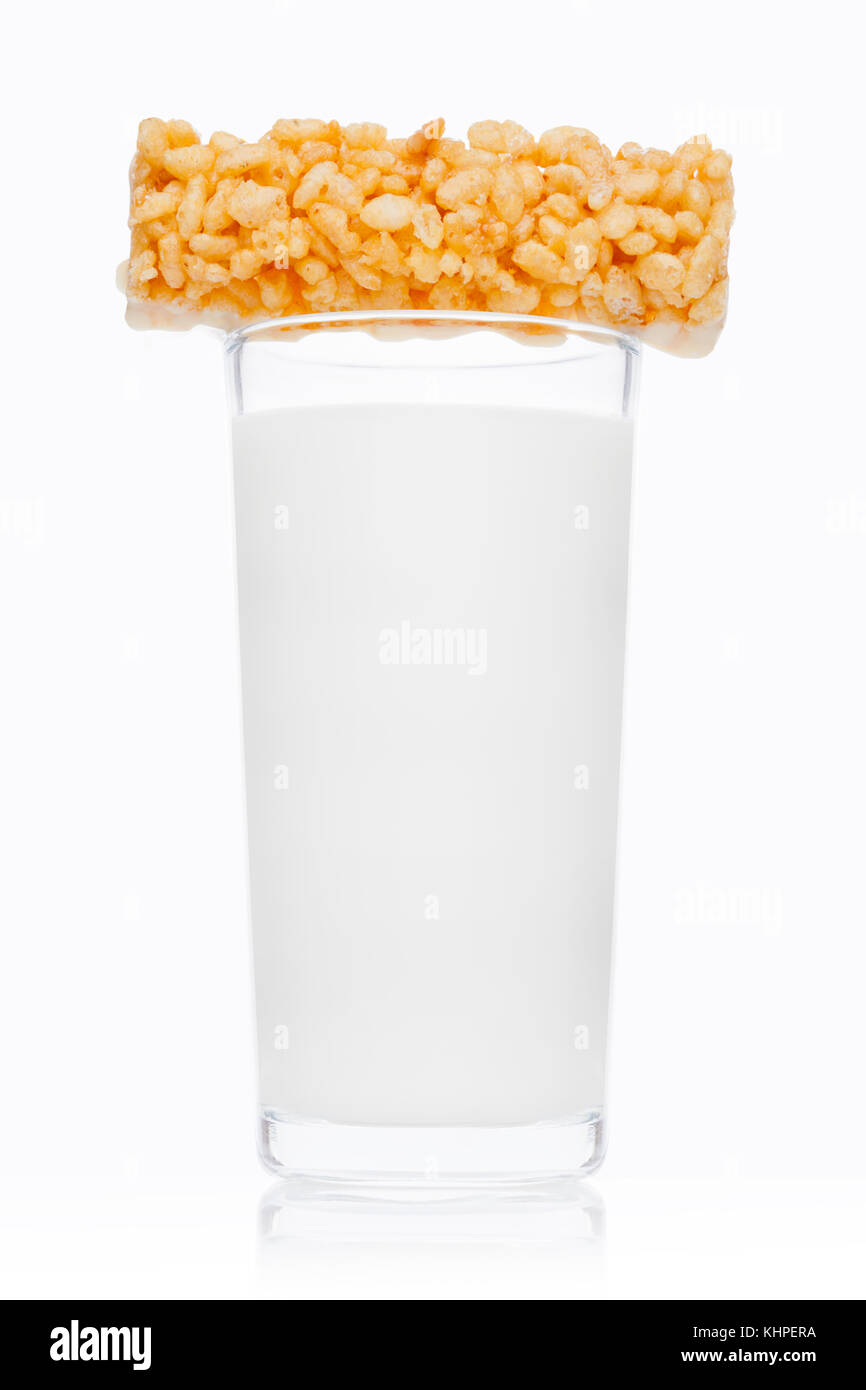 Glass of fresh breakfast milk with crisp cereal bar on white background ...