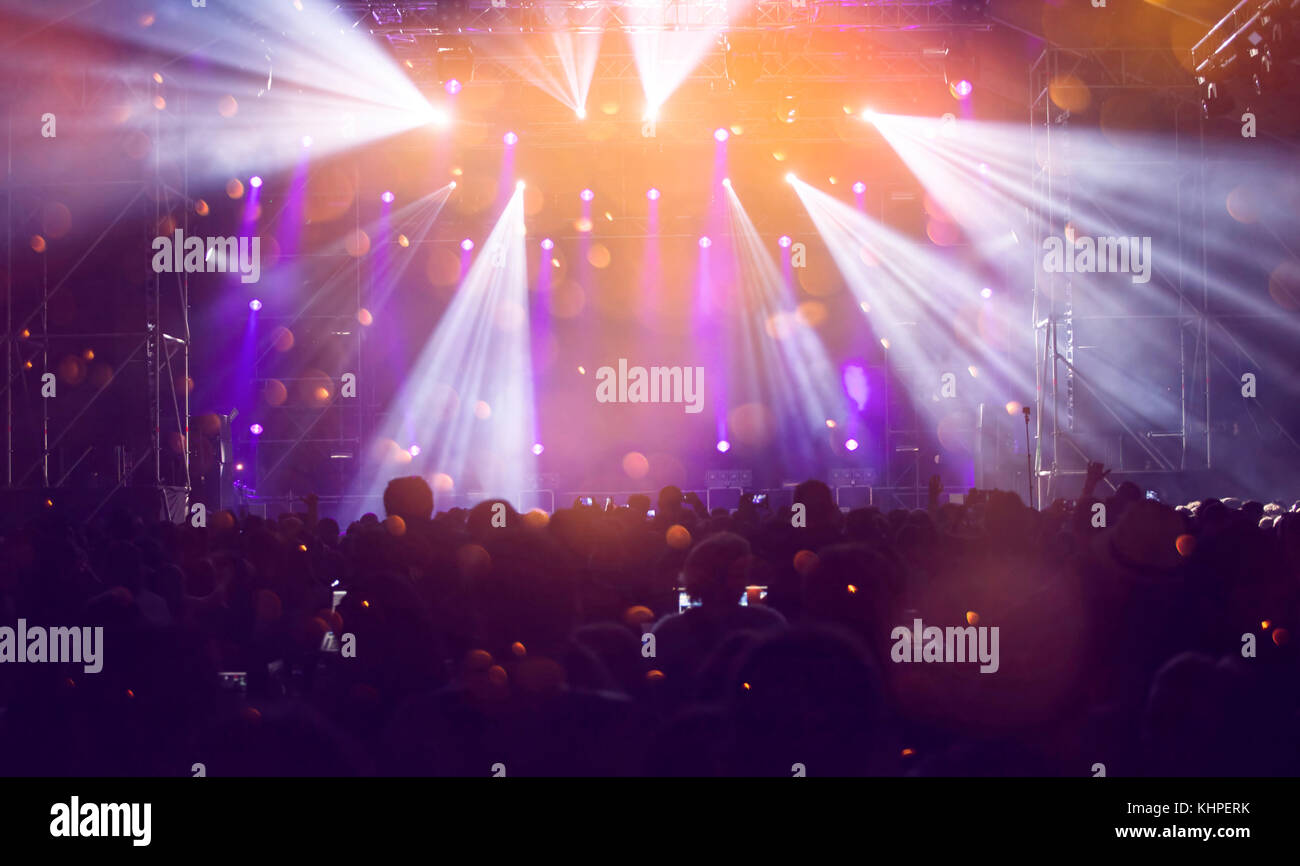 Crowd at concert - Cheering crowd in front of bright colorful stage ...