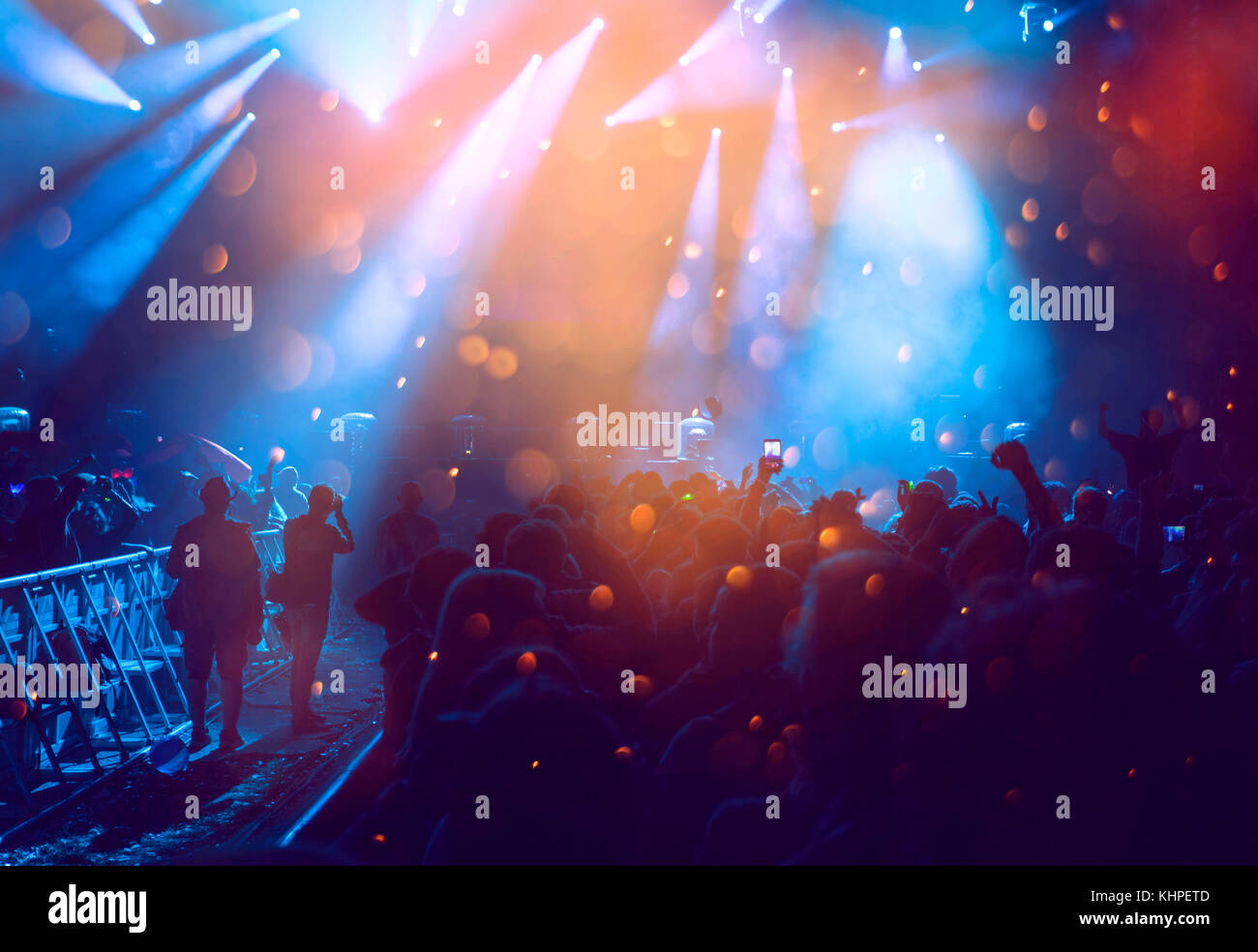 Crowd at concert - Cheering crowd in front of bright colorful stage ...