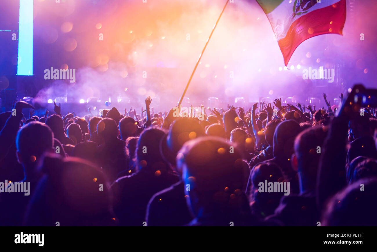 Crowd at concert - Cheering crowd in front of bright colorful stage ...