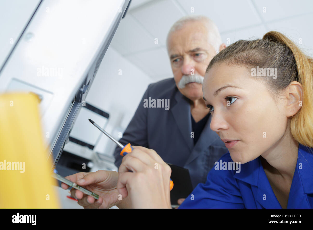 woman working on electronic device with senior teacher Stock Photo - Alamy