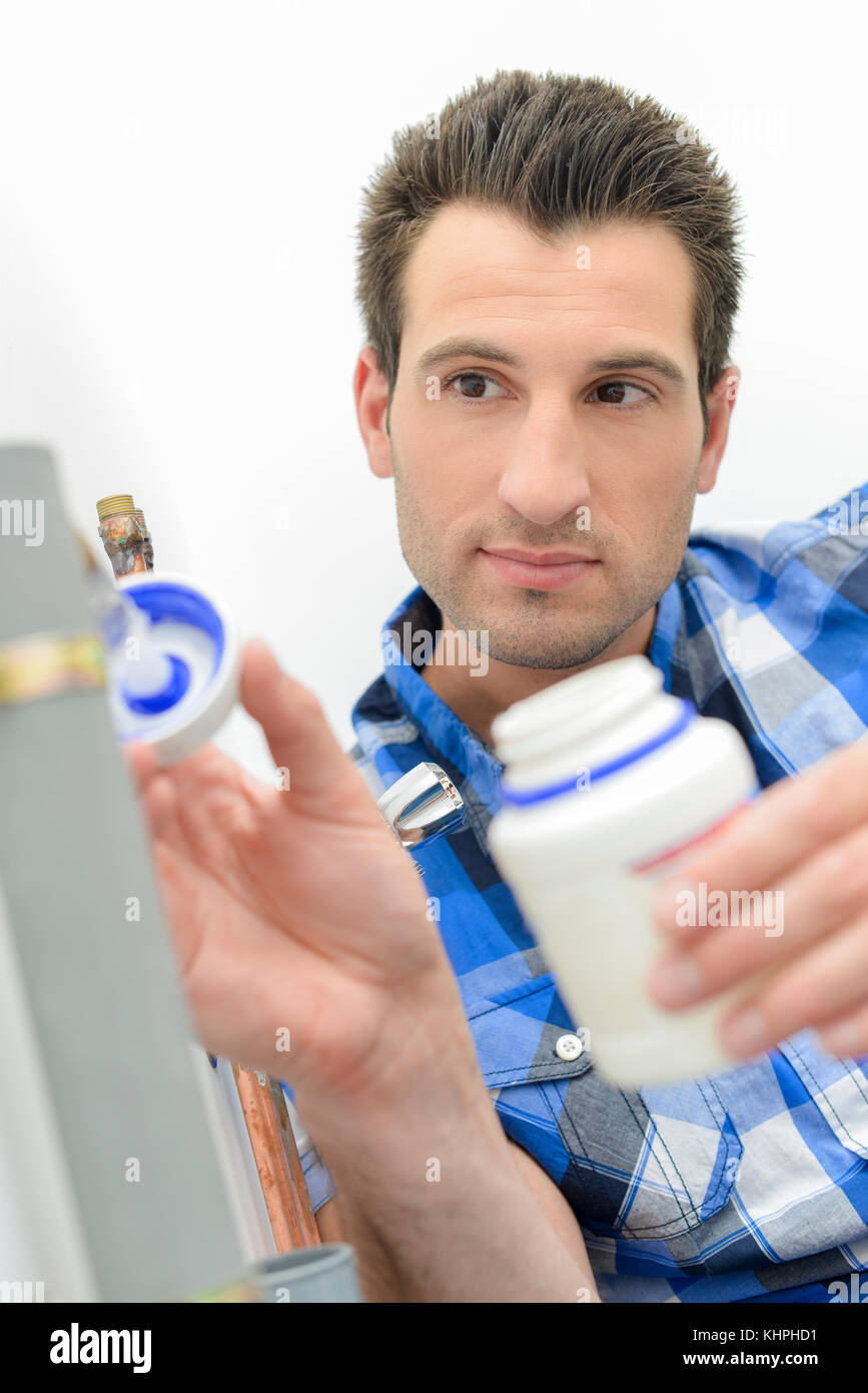 Plumber using some glue Stock Photo - Alamy