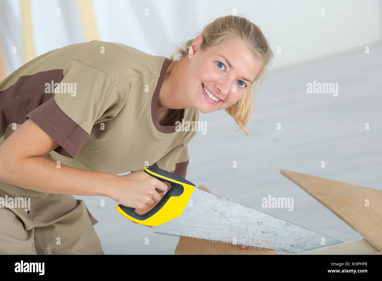 Woman using hand saw Stock Photo - Alamy
