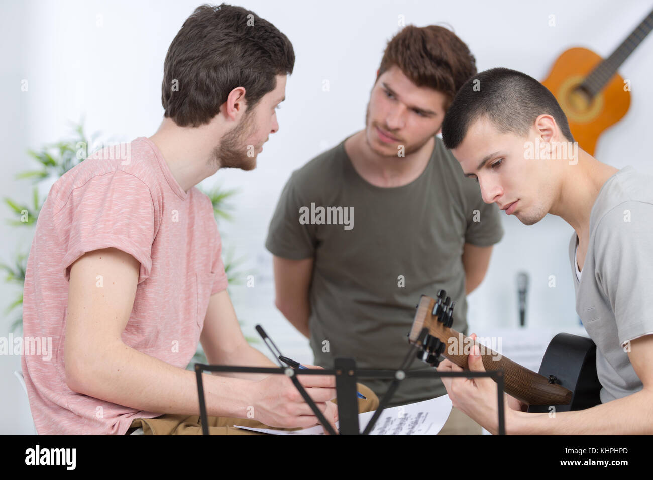 Three young guitarists in discussion Stock Photo - Alamy
