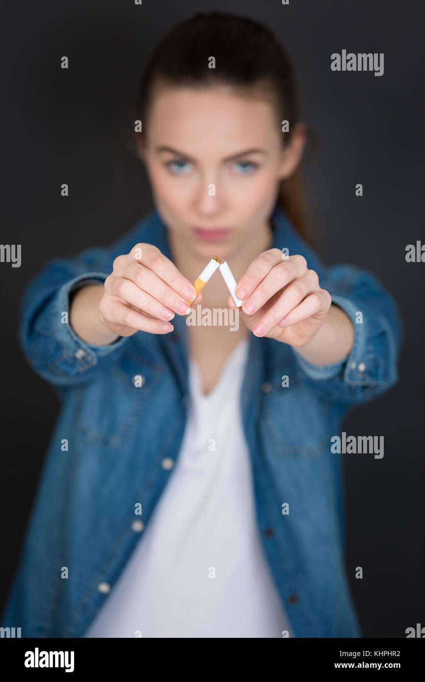 young woman is breaking a cigarette Stock Photo - Alamy