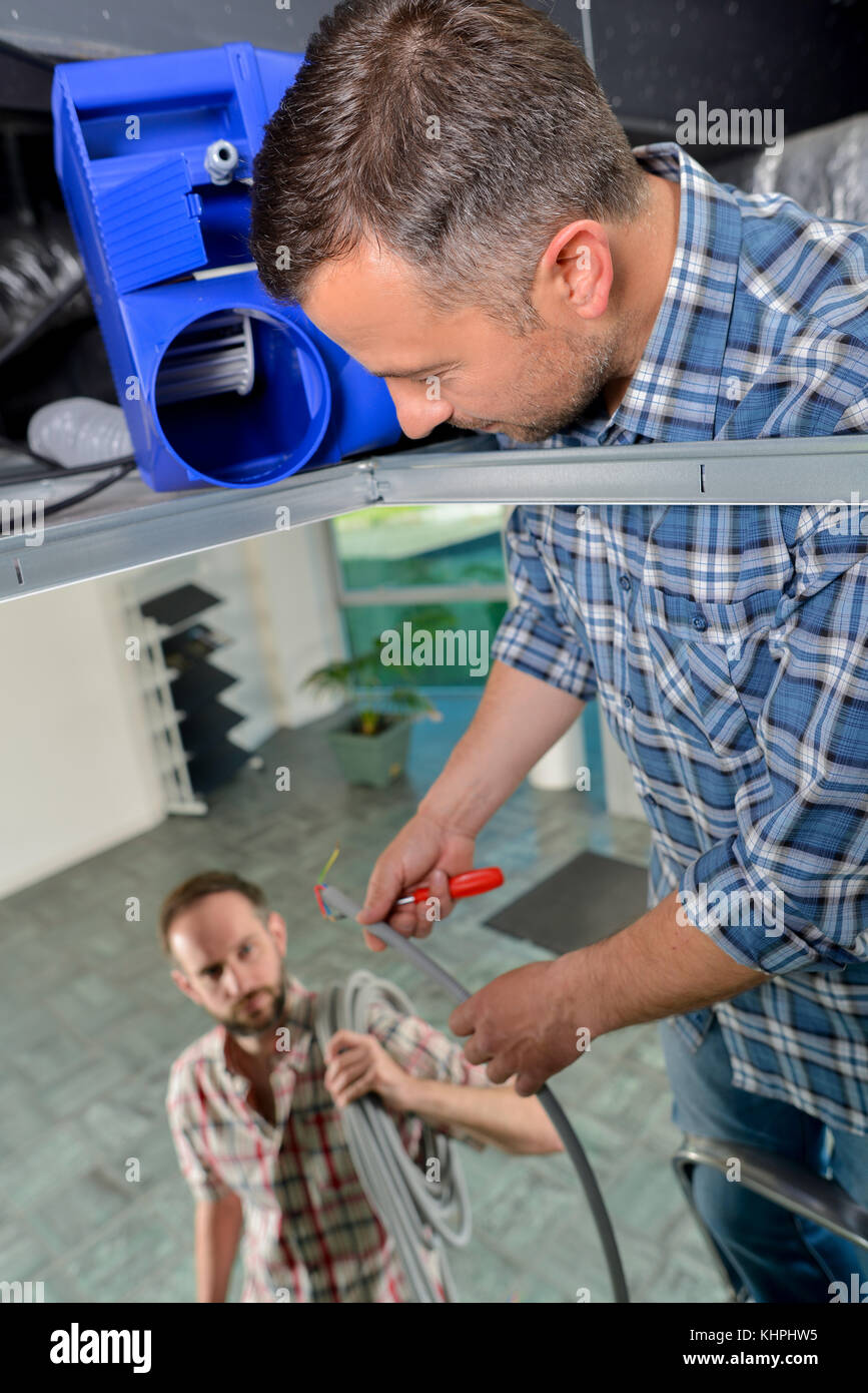 Two men with cable conduit Stock Photo - Alamy