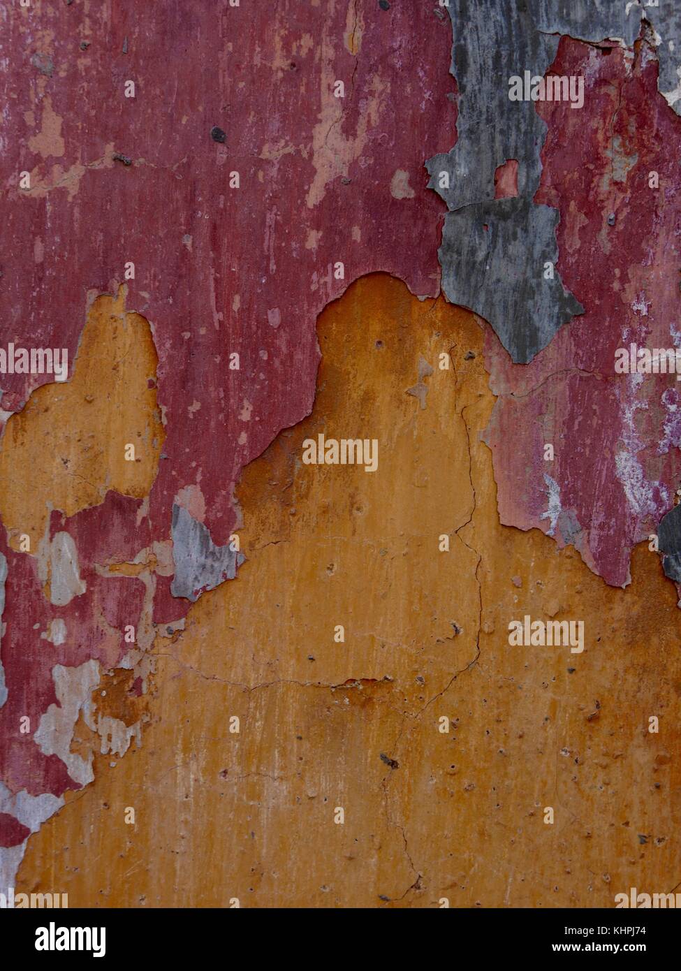 Textured background/backdrop of dark red, ochre and grey peeling paint ...