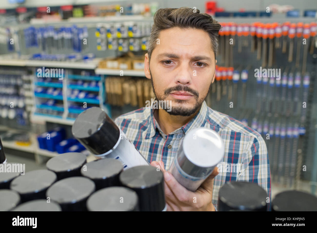 man chooses spray for polishing car in shop Stock Photo - Alamy