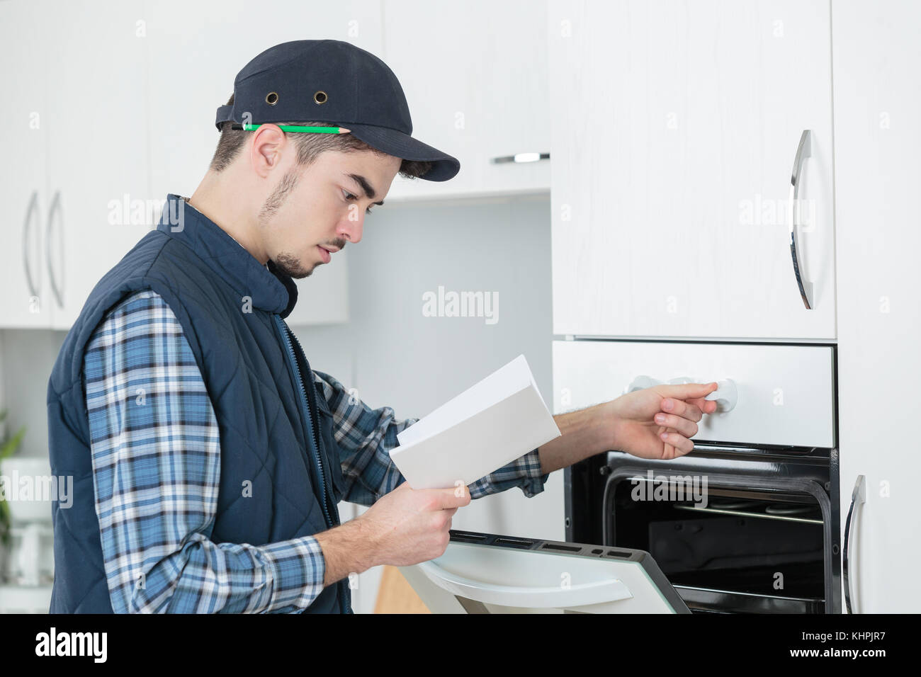 Young man installing oven Stock Photo - Alamy