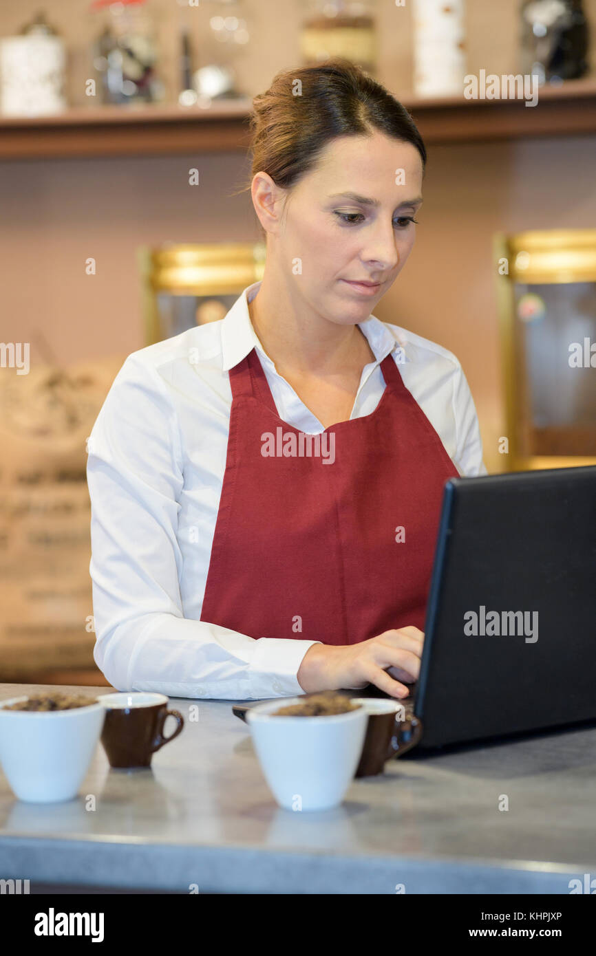 Cafe worker using laptop Stock Photo - Alamy