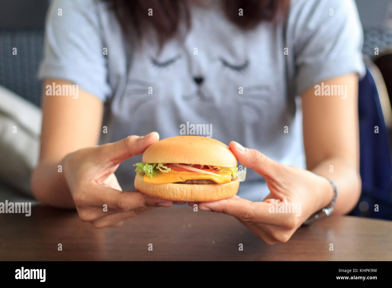 Burger in the young woman hand, holding in woman hands fast food burger ...