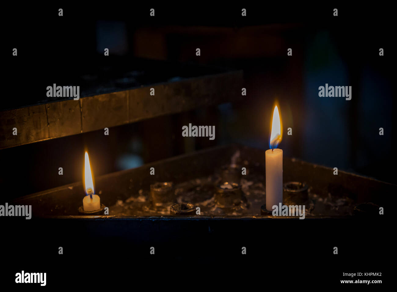 Votive candles or prayer candles lit as offering to God Stock Photo - Alamy