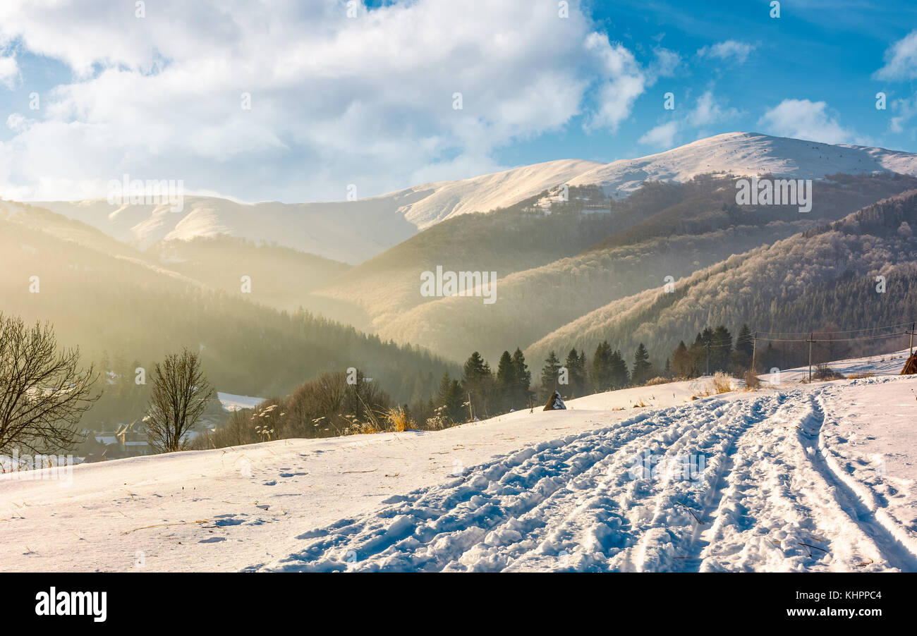snowy mountain ridge above the rural area. lovely countryside winter ...