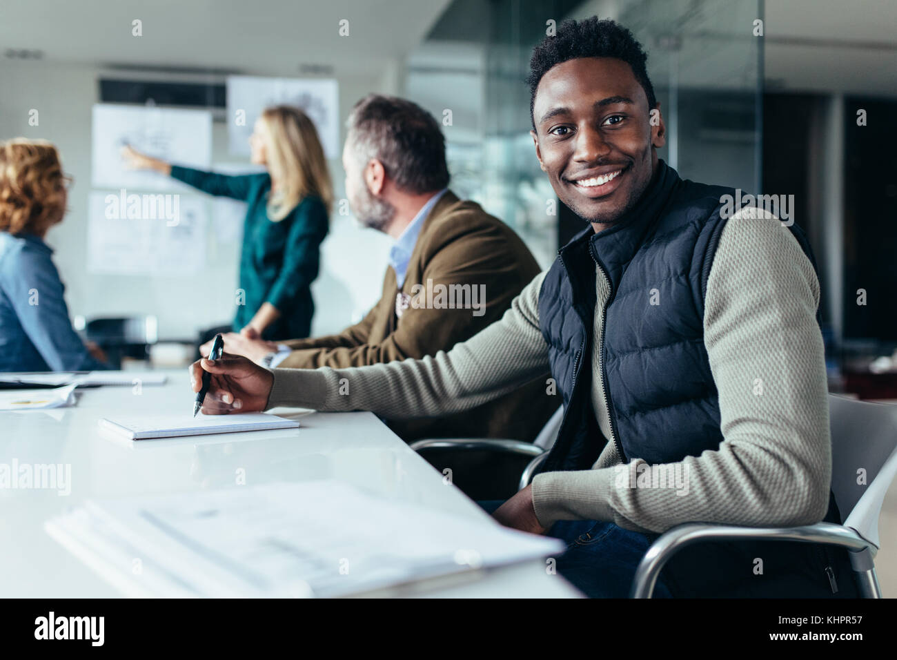 Young businessman sitting in conference room. Black man looking at ...