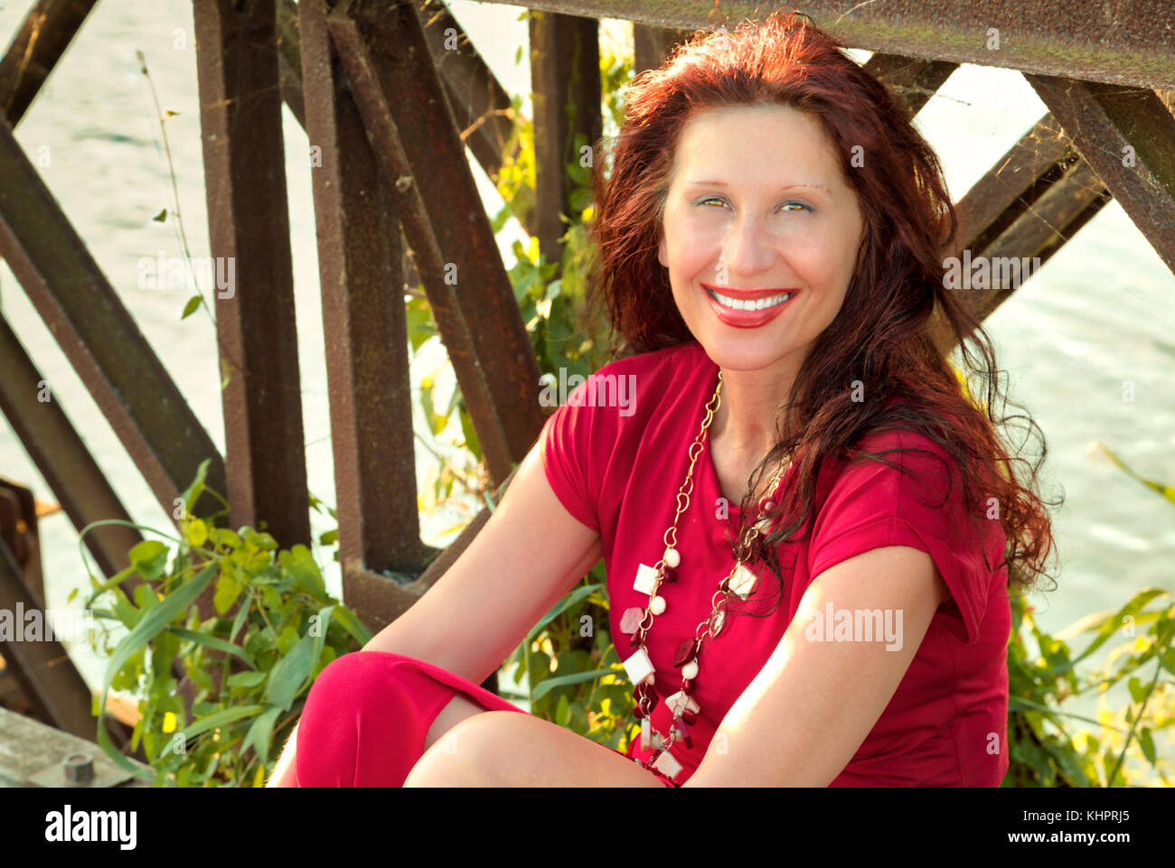 Russian girl sitting on iron bridge and smiling Stock Photo - Alamy