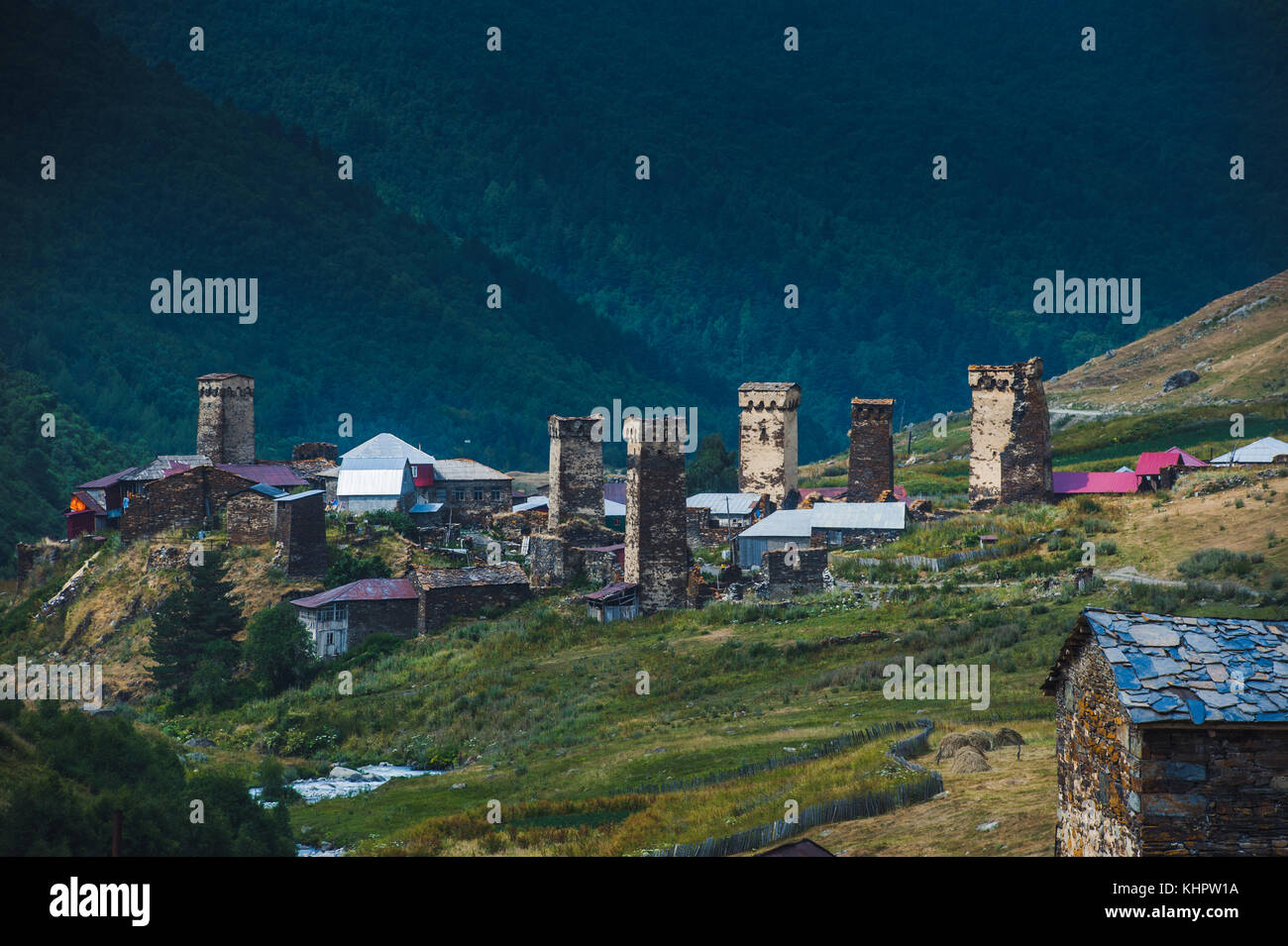 Village Ushguli landscape with massive rocky mountains Bezengi wall ...